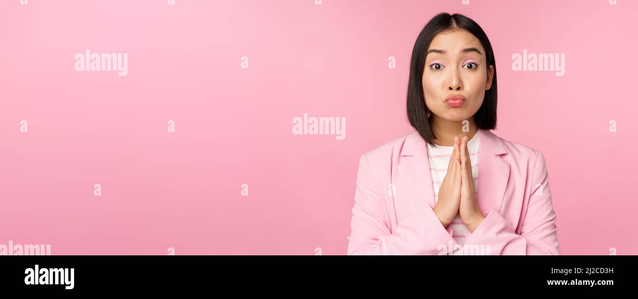 Portrait of asian businesswoman asking for help, say please, standing ...