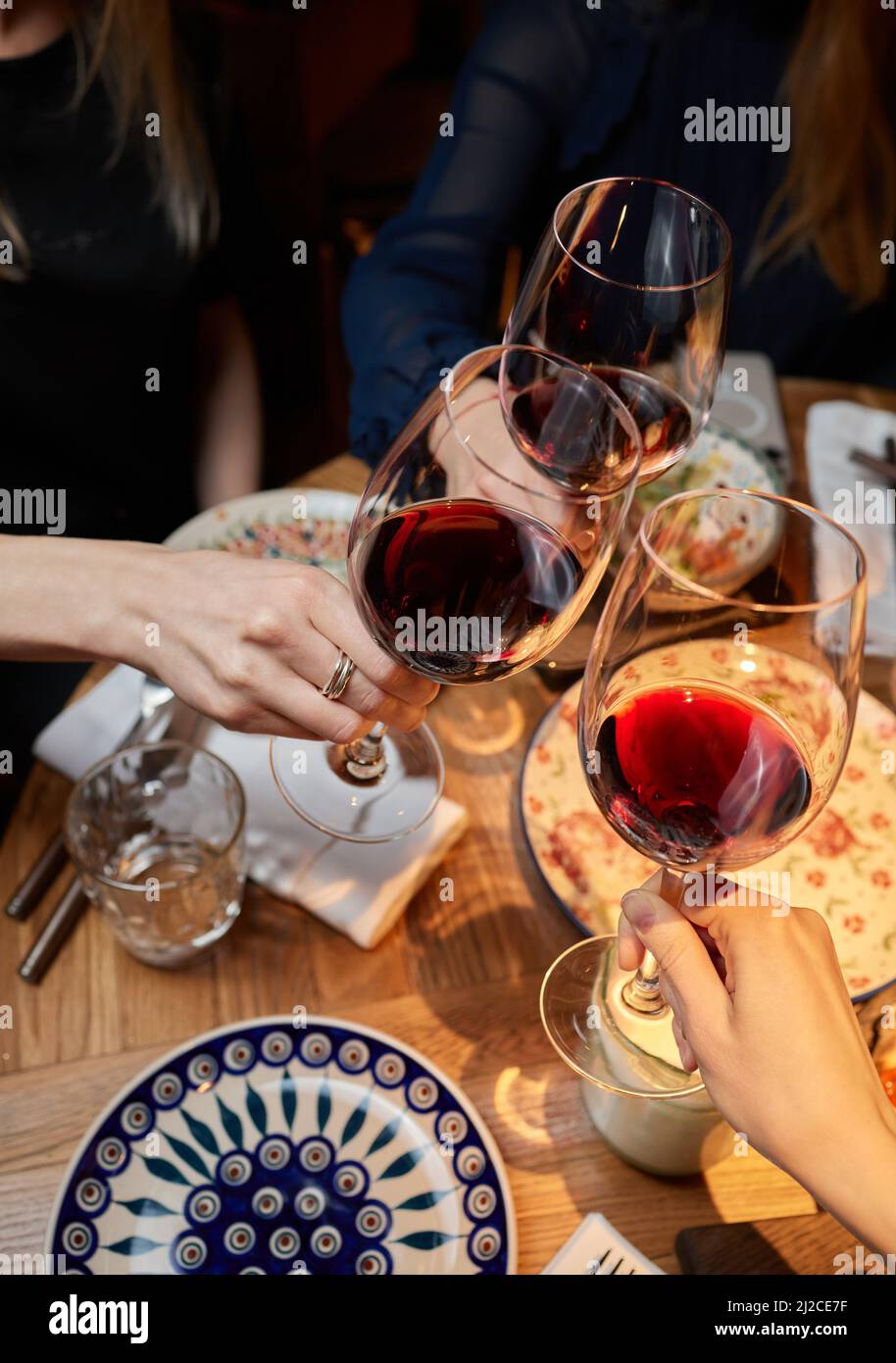 Celebrating with glasses of alcohol in hands. Happy female friends ...