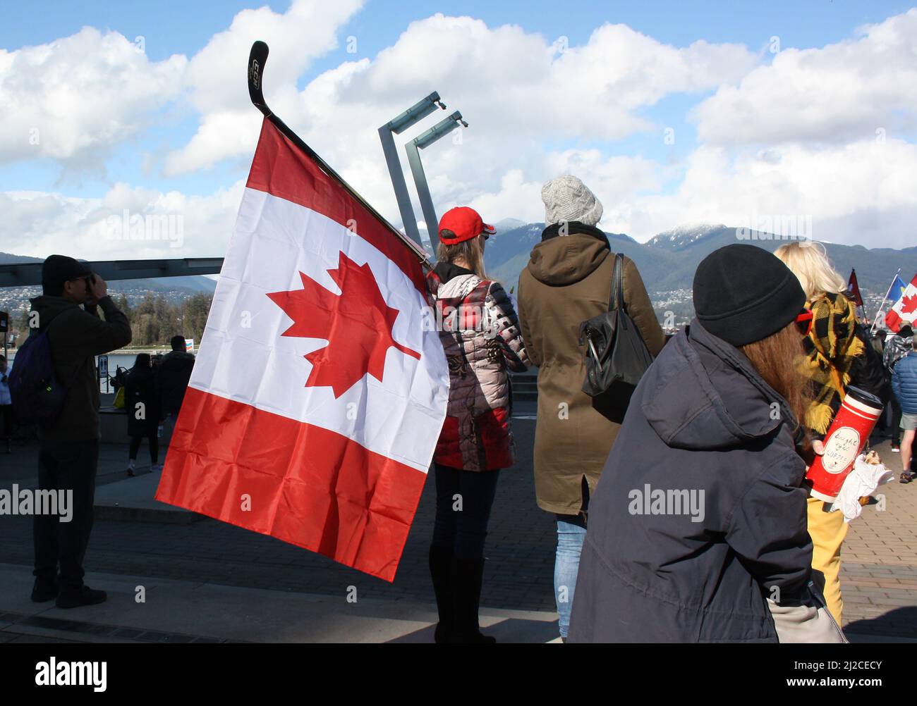 A crowd protesting with Canadian flags and slogans in downtown ...