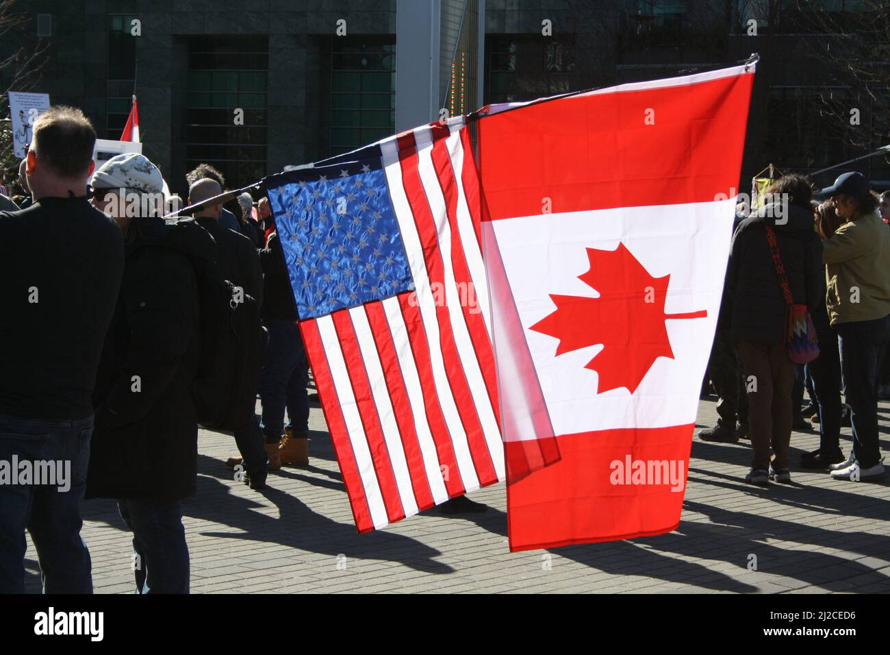 A crowd protesting with Canadian flags and slogans in downtown ...