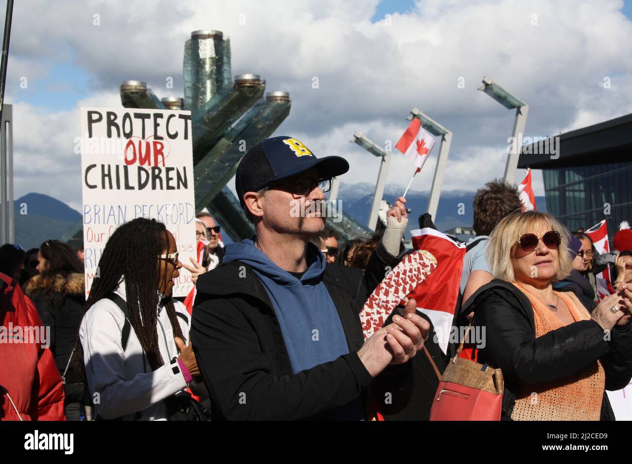 A crowd protesting with Canadian flags and slogans in downtown ...