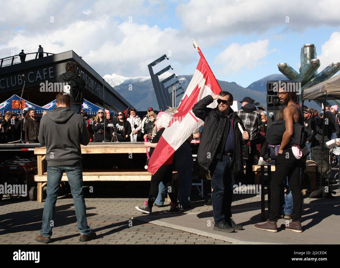 A crowd protesting with Canadian flags and slogans in downtown ...