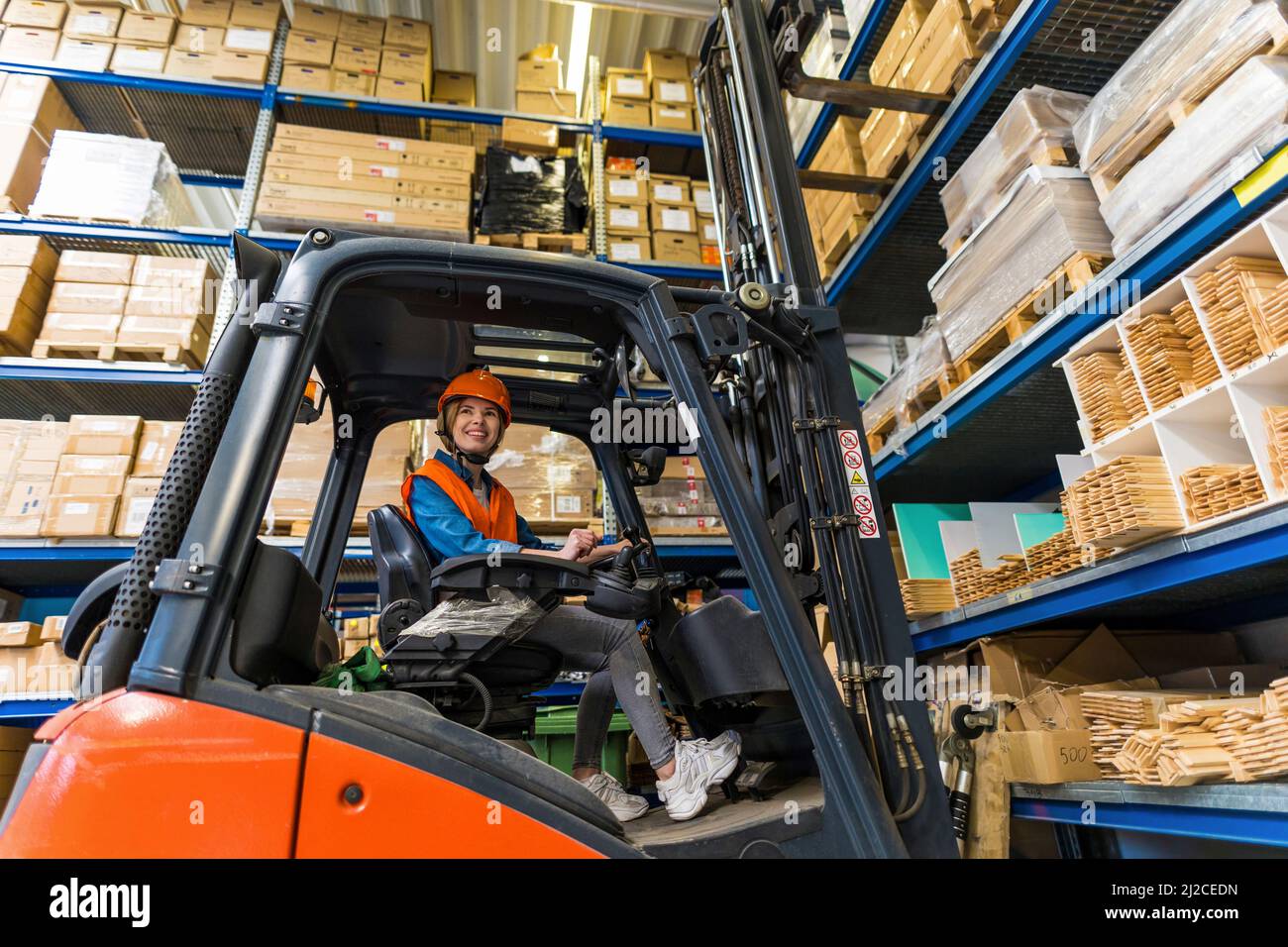 Young female forklift driver working in a warehouse Stock Photo - Alamy