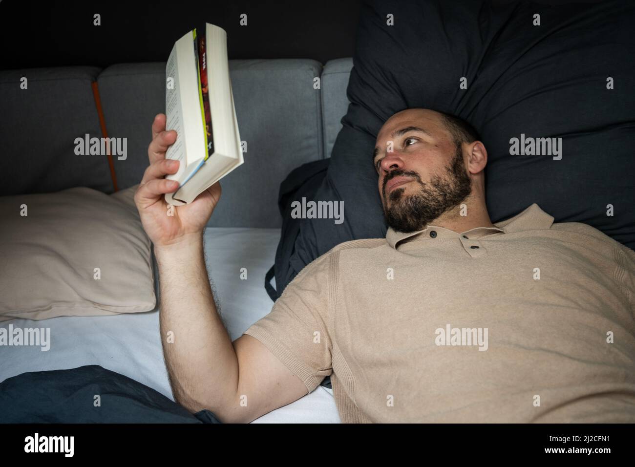 Man reads a fantasy book in bed Stock Photo - Alamy