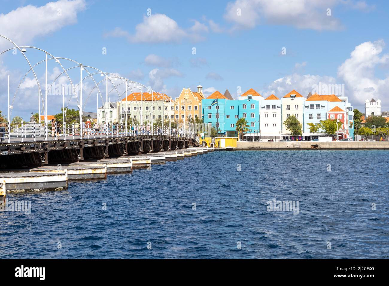 The famous Queen-Emma-Bridge with colorful buildings of the district ...