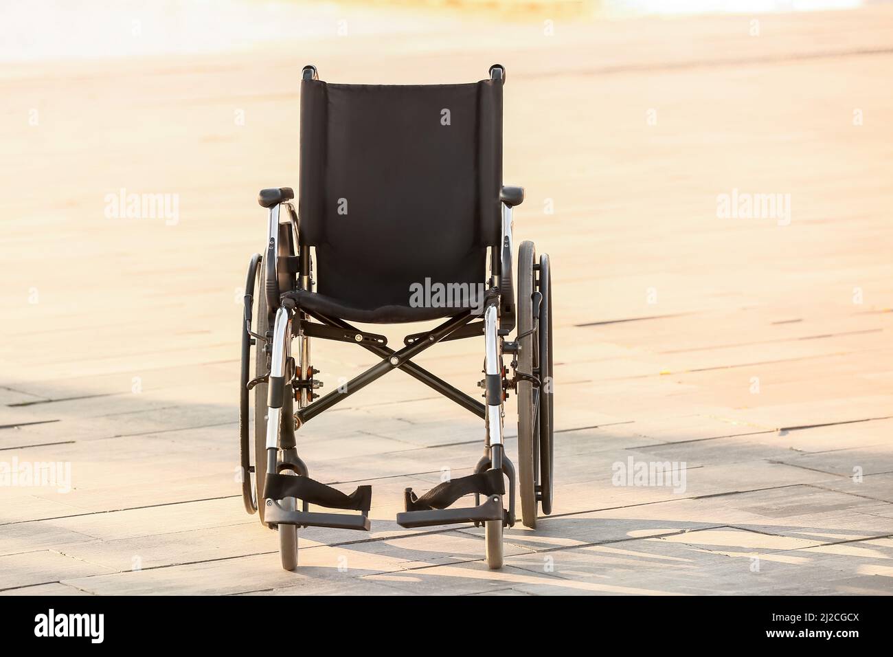 Empty modern wheelchair on city street Stock Photo - Alamy