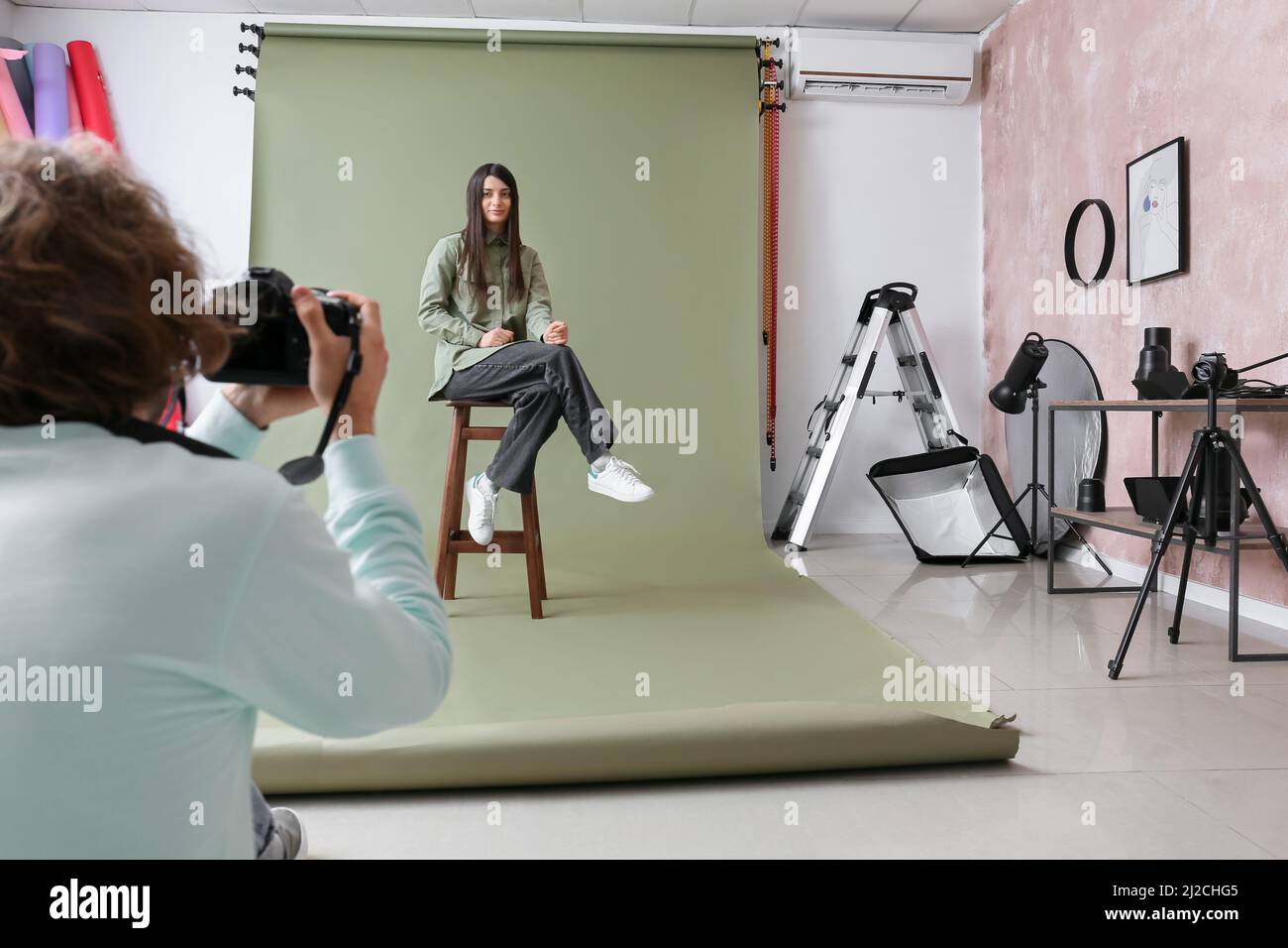 Photographer taking picture of female model in studio Stock Photo - Alamy