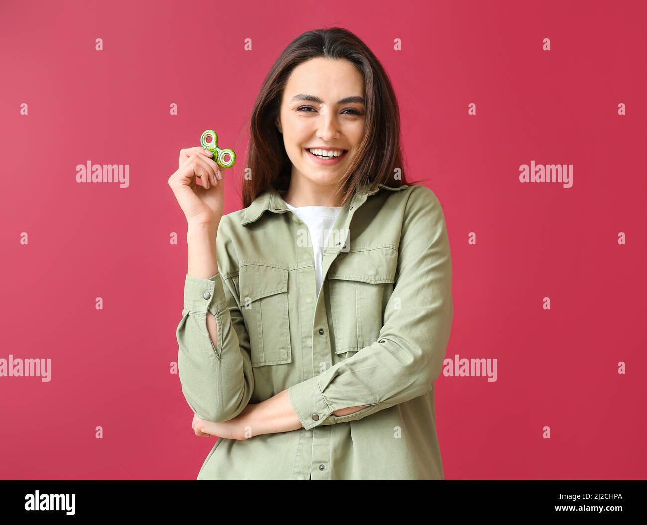Beautiful young woman with spinner on color background Stock Photo - Alamy
