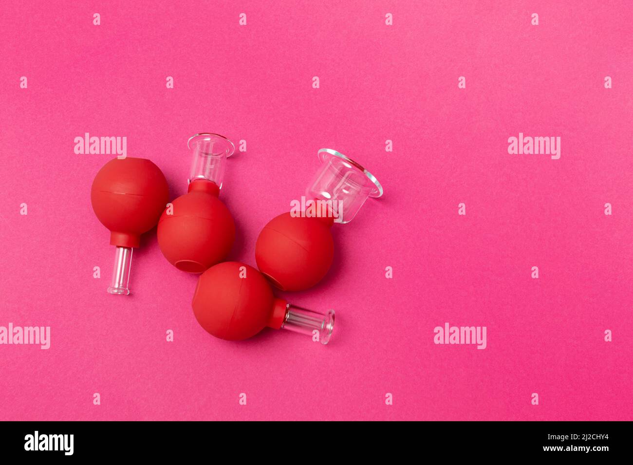 Glass facial and body cupping set on red background Stock Photo - Alamy