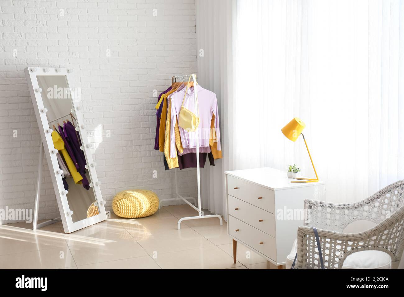 Interior of light dressing room with clothes, mirror and commode Stock ...