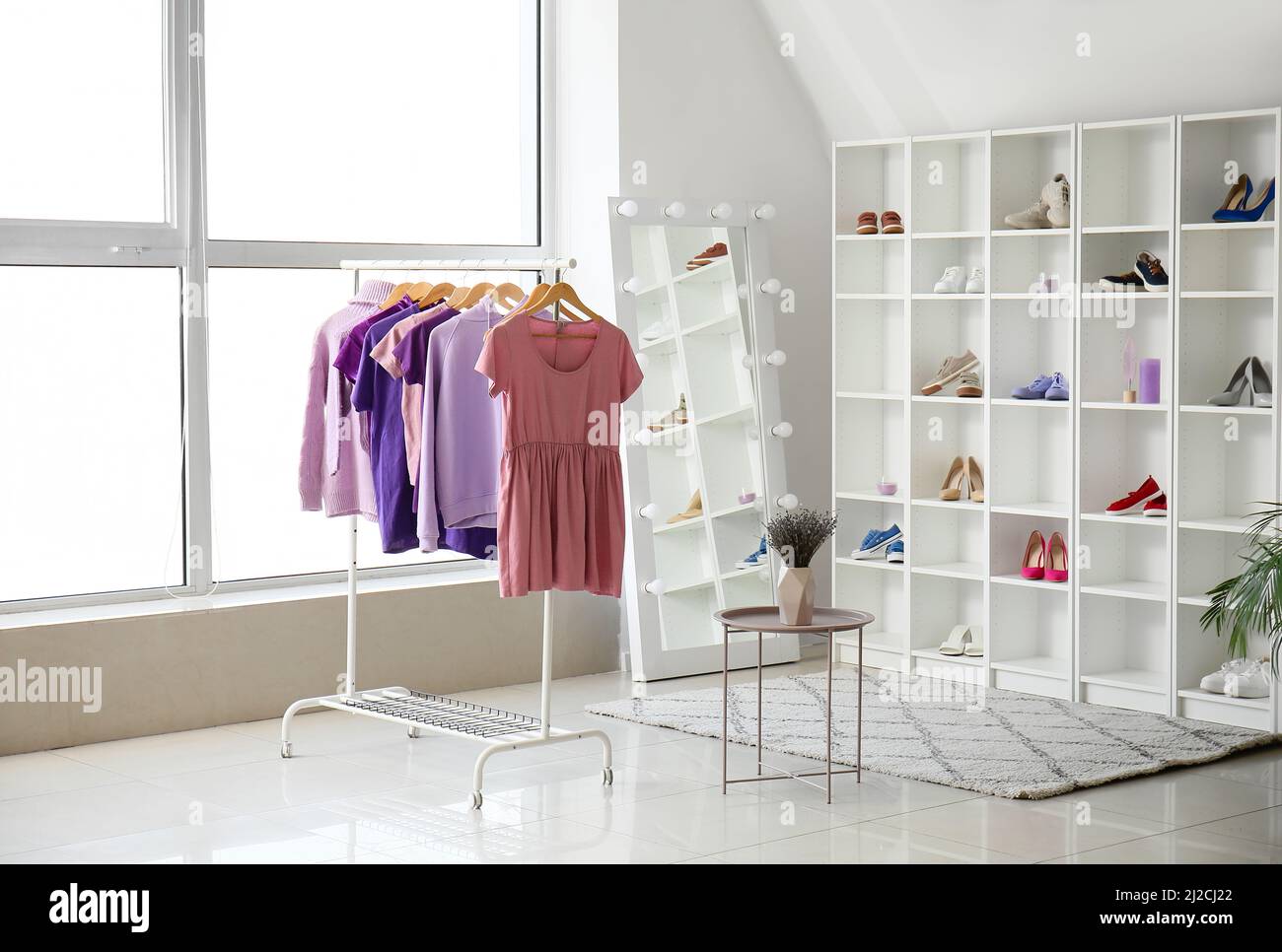 Rack with clothes, shoes, shelving unit and mirror in dressing room ...