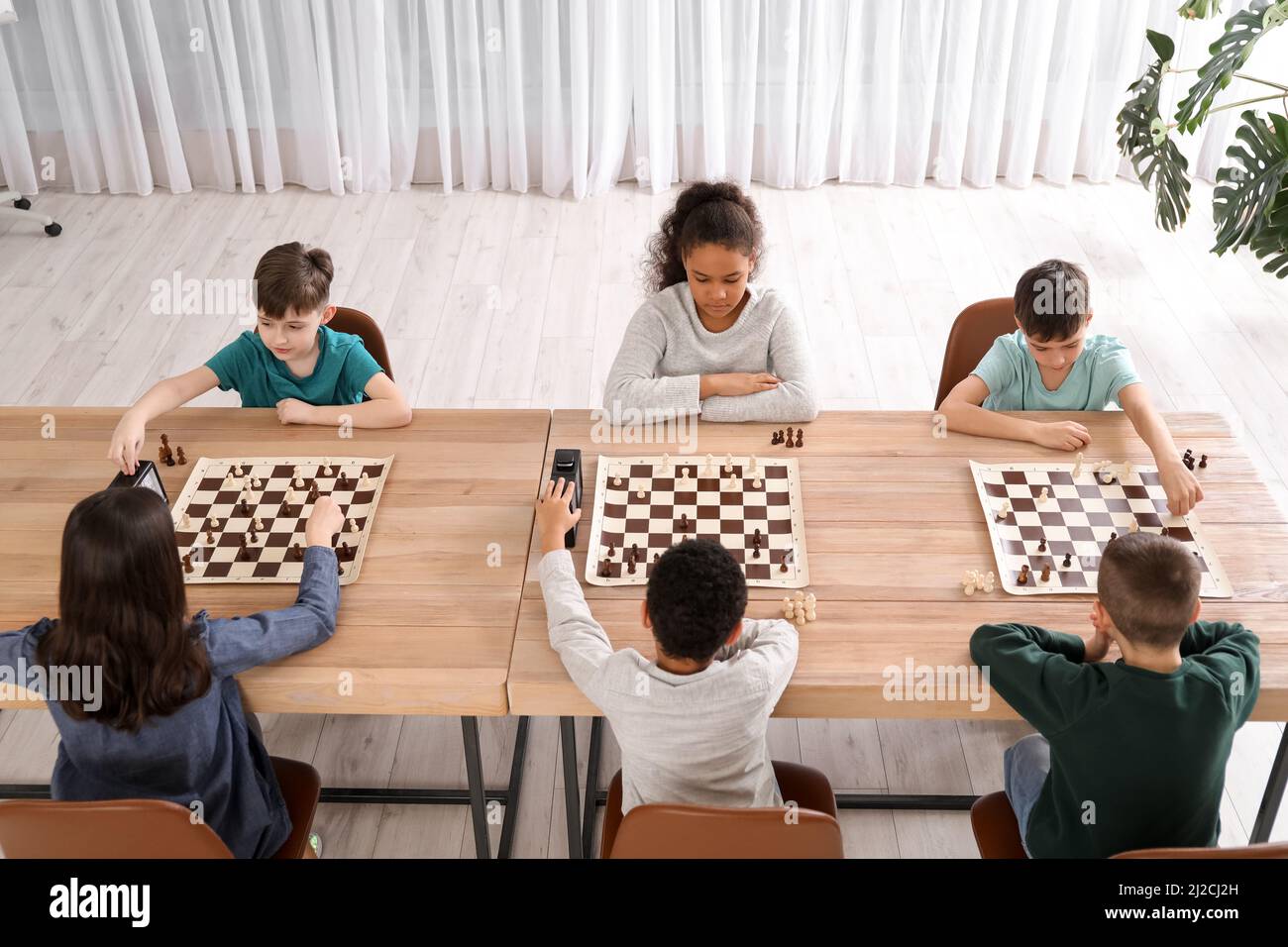 Little children playing chess during tournament in club Stock Photo - Alamy