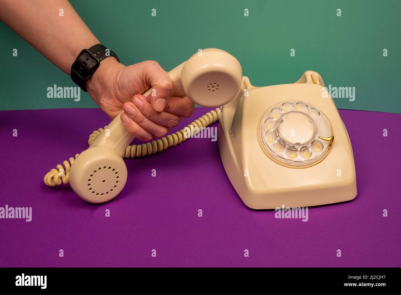 Woman's hand picking up an old phone Stock Photo - Alamy