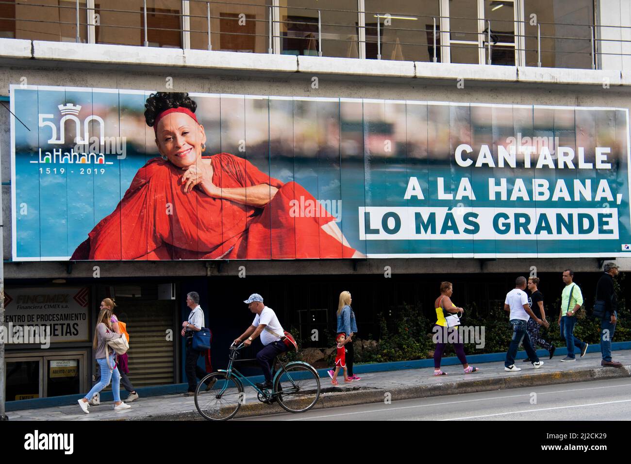 Street scene in Havana, Cuba. People walk past a beautiful mural ...