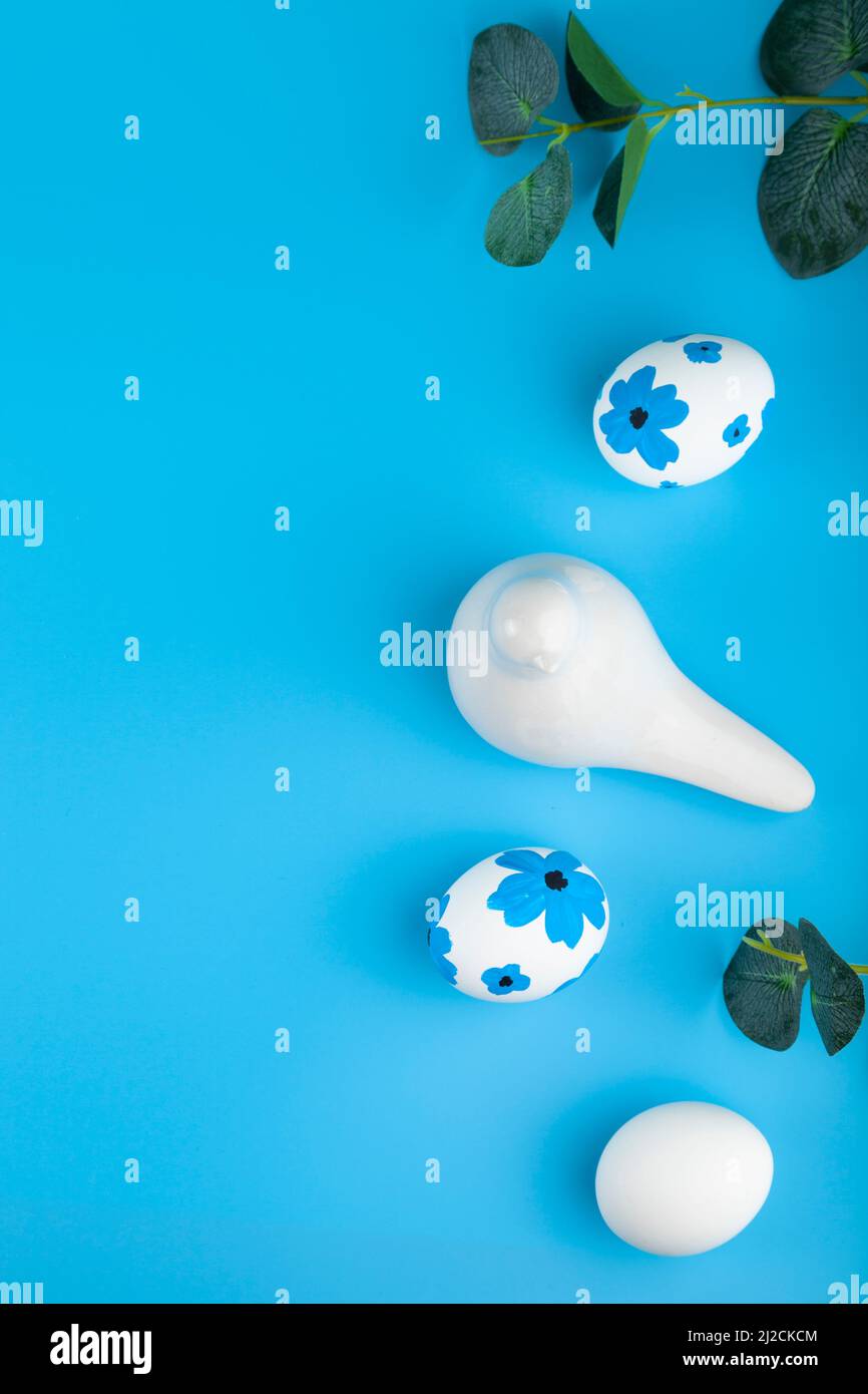 Frame of Easter eggs, decorations and flowers on color background ...