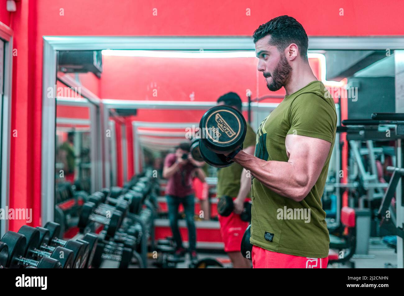 A young fit Caucasian male powerlifting at the gym while working out in ...