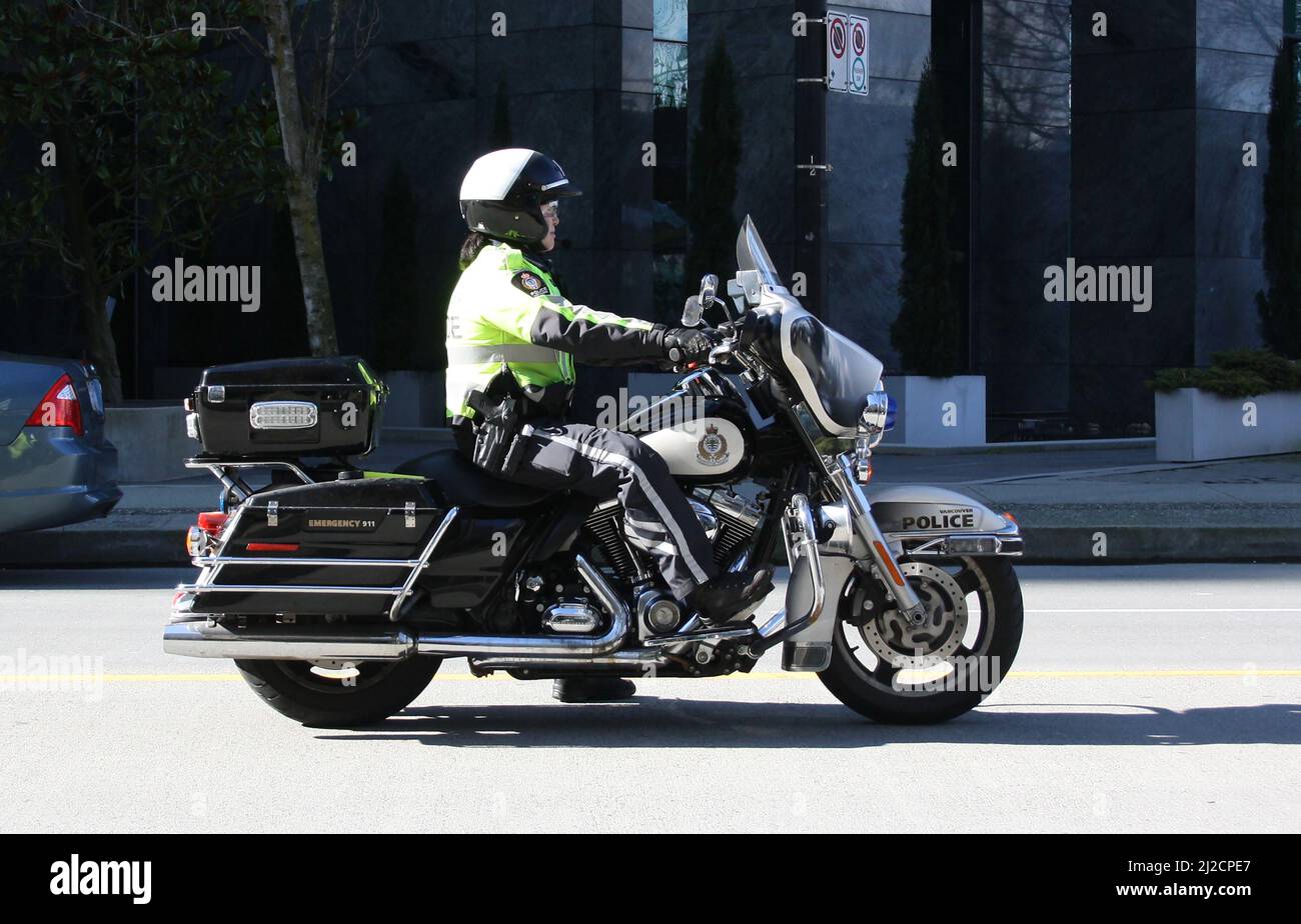 A police officer riding a classic motorcycle in downtown Vancouver ...