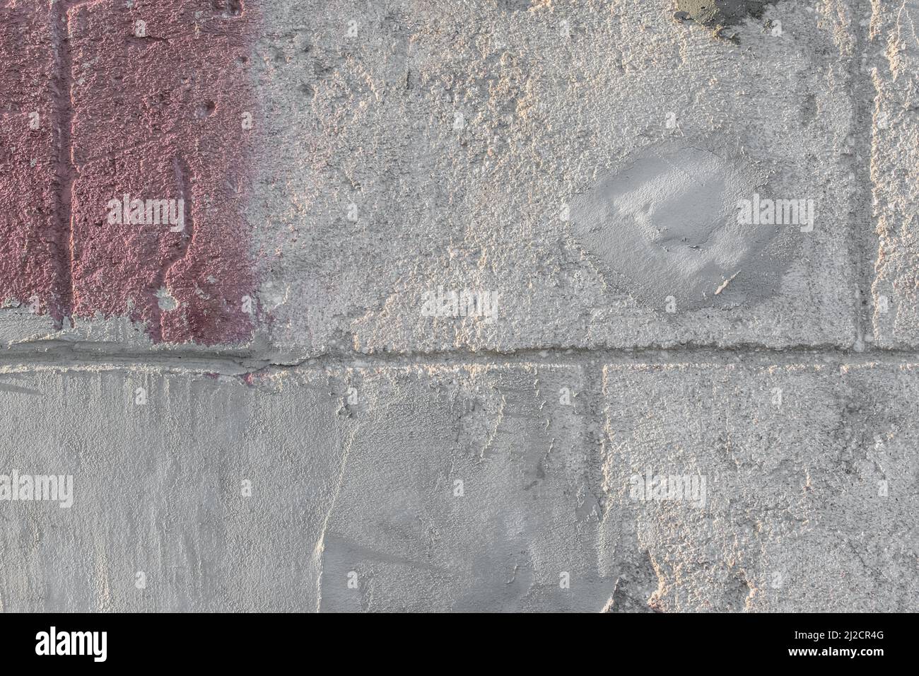 Old wall of concrete blocks in pink paint and cement stains texture ...