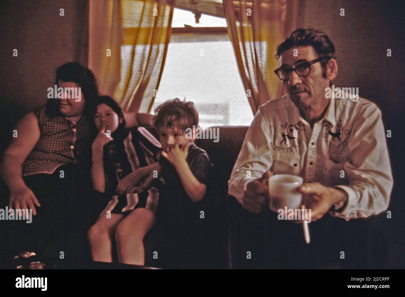 Mrs. May Watkins with family members, sit on the couch in their new ...