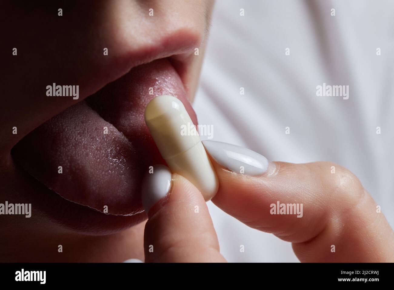 Close up of face of young woman taking drug. The drug addict is ...