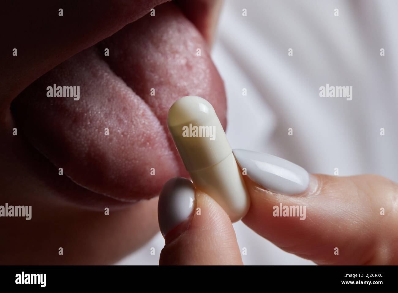 Close up of face of young woman taking drug. The drug addict is ...