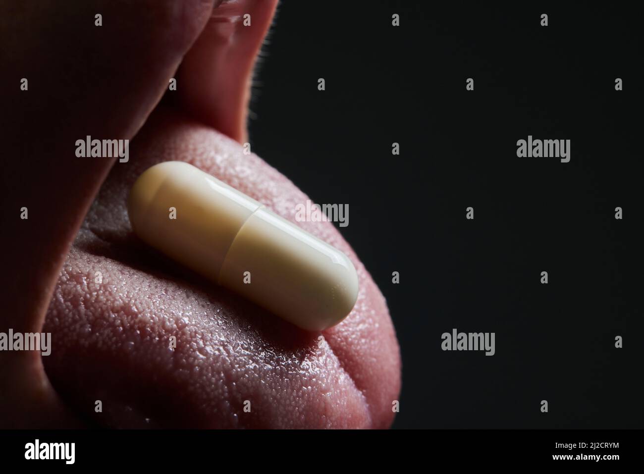 Close up of face of young woman taking drug. The drug addict is ...