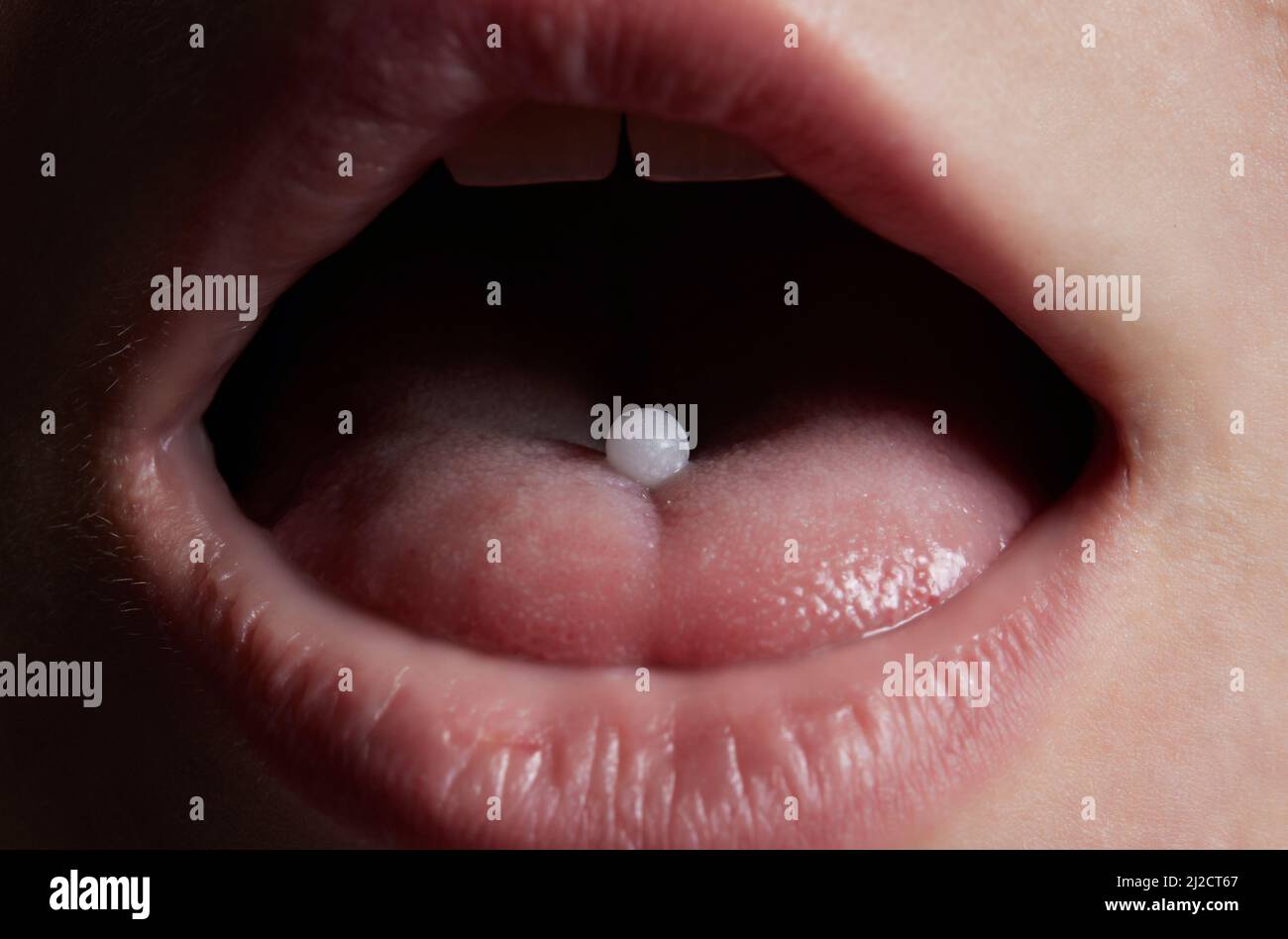 Close up of face of young woman taking drug. The drug addict is ...