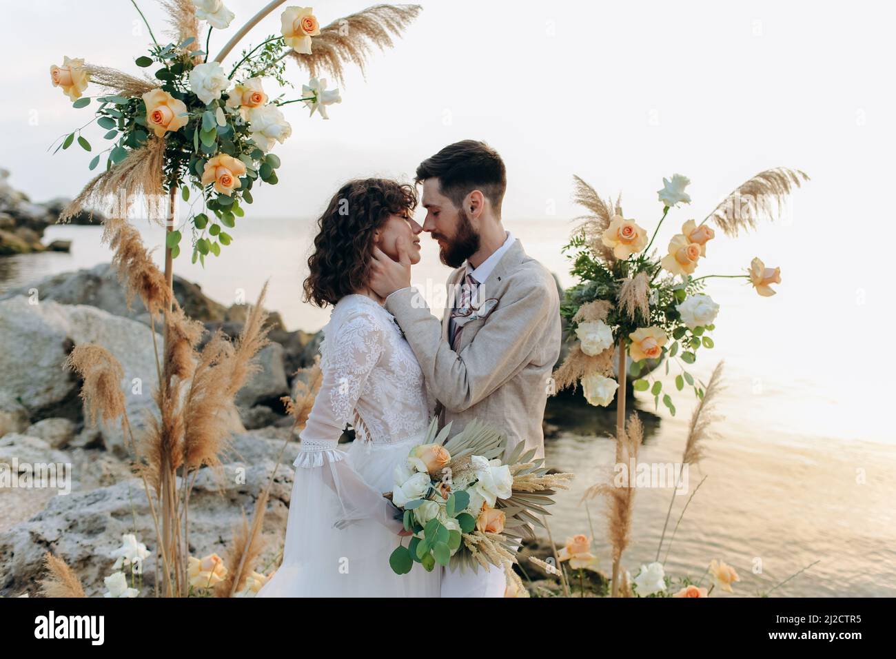 Wedding on the sunset with live floristry. Bride and groom in boho ...