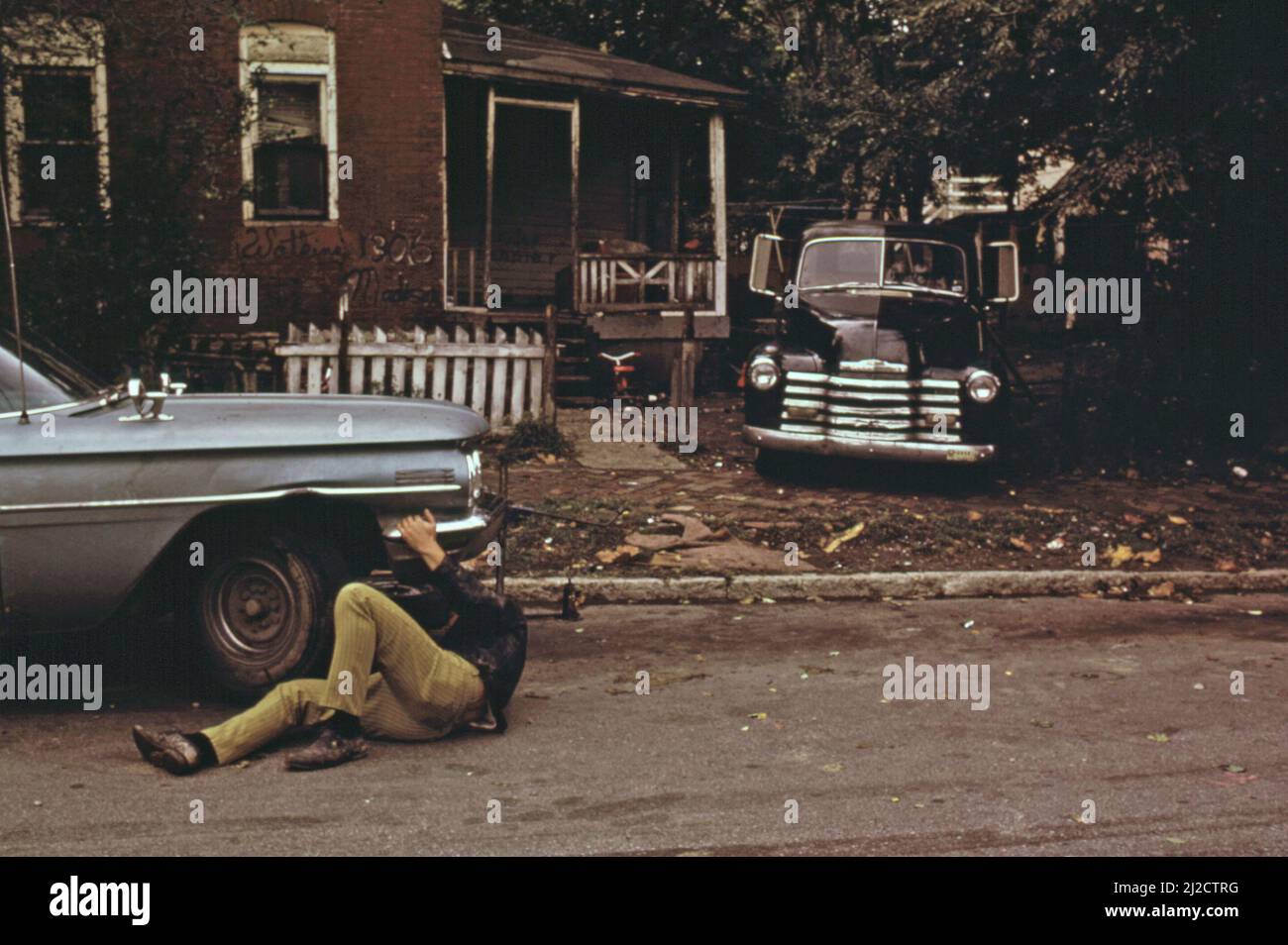 Man working on an automobile in front of their Mulkey Square ...