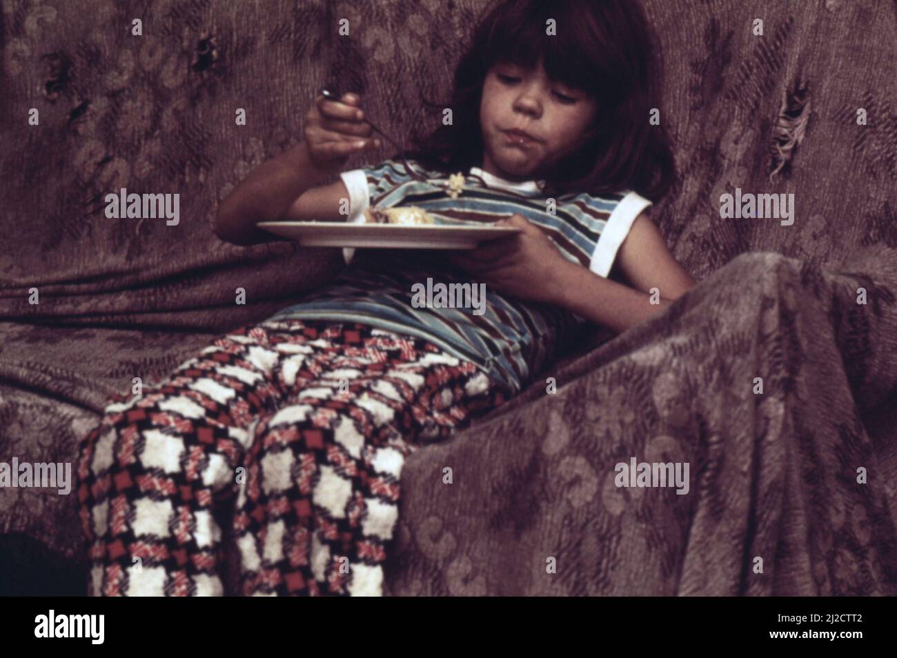 Diane Watkins, one of nine children of a Mulkey Square family eats on ...