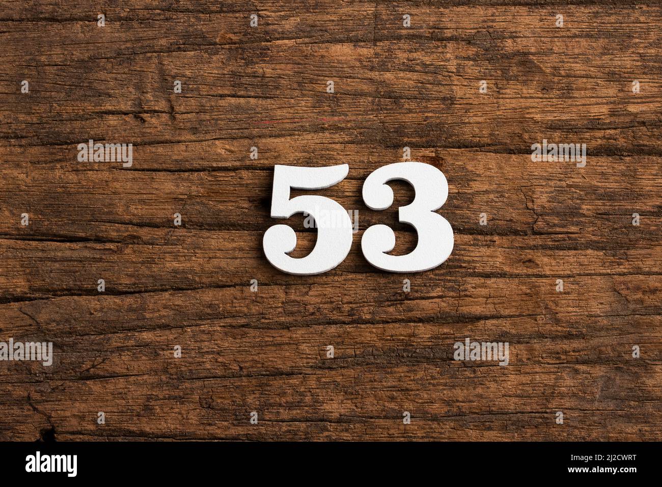 Number 53 - piece on rustic wood background Stock Photo - Alamy