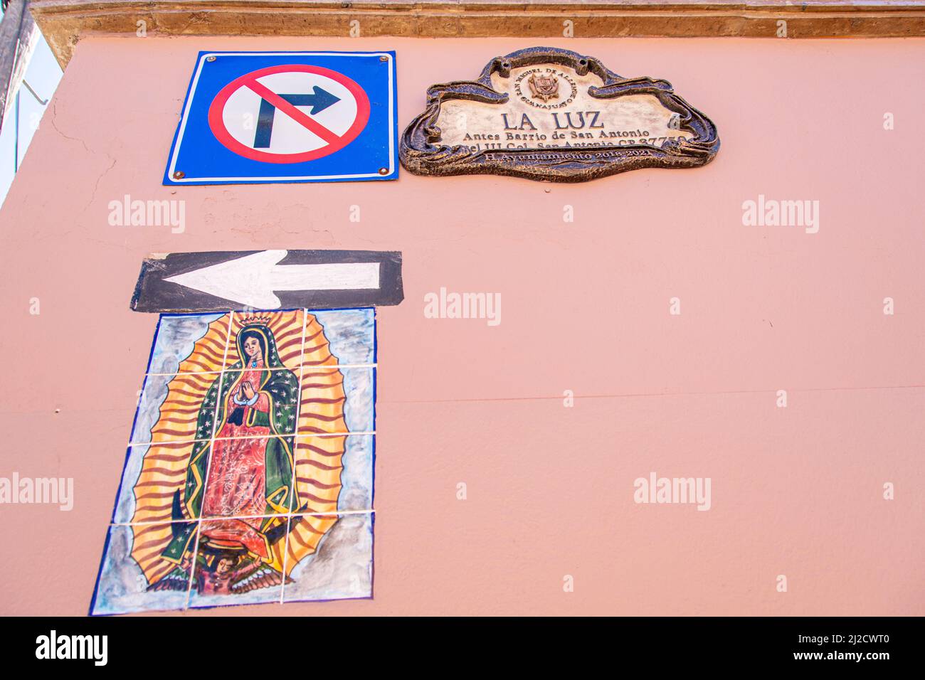 Various signs/objects on a wall including; no left turn, direction ...