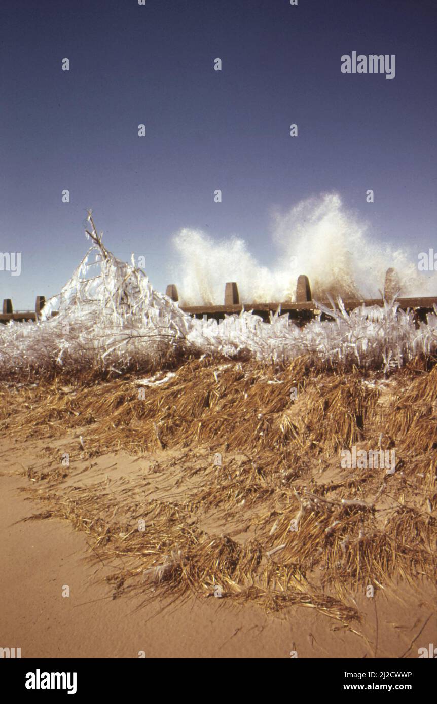 Waves, whipped up by a northeast gale, crash against the seawall and ...