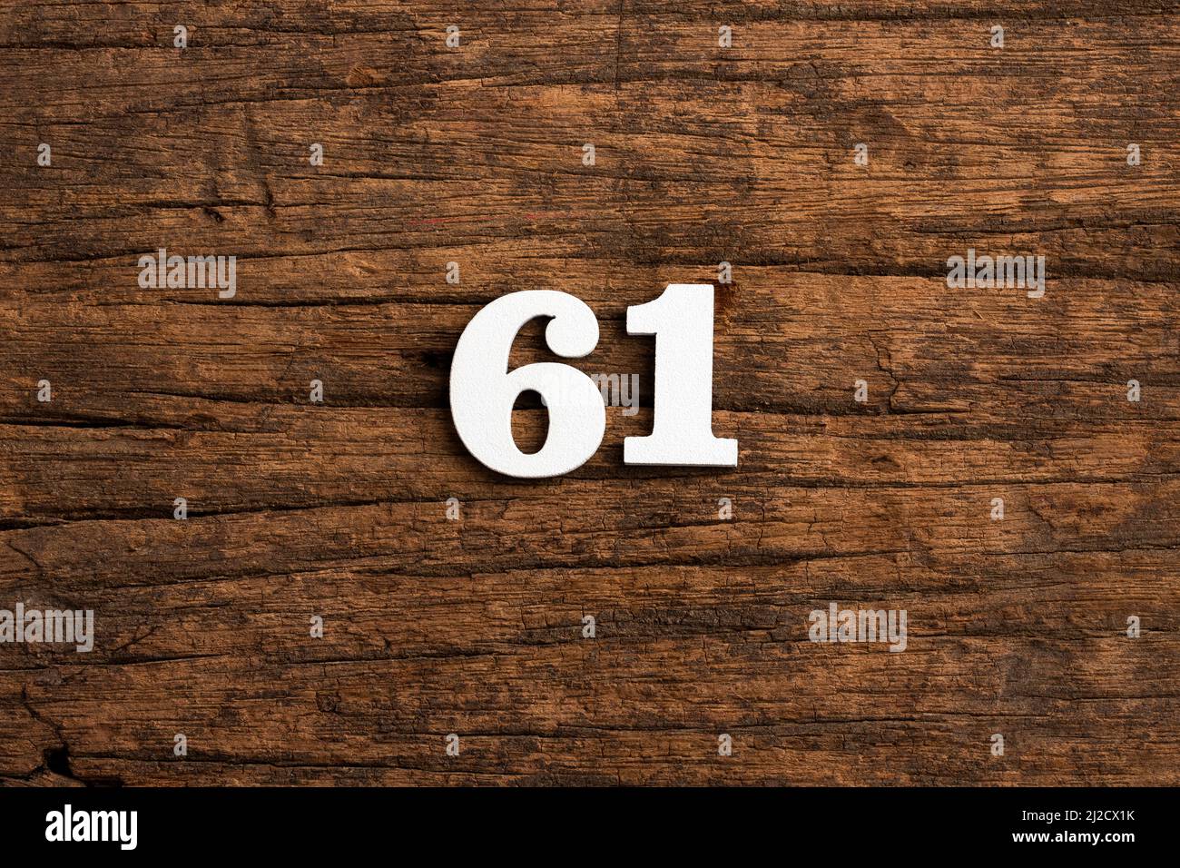 Number 61 - piece on rustic wood background Stock Photo - Alamy