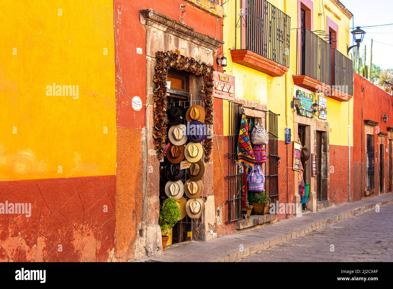 A cobblestone street lined with shops selling everything from Mexican ...