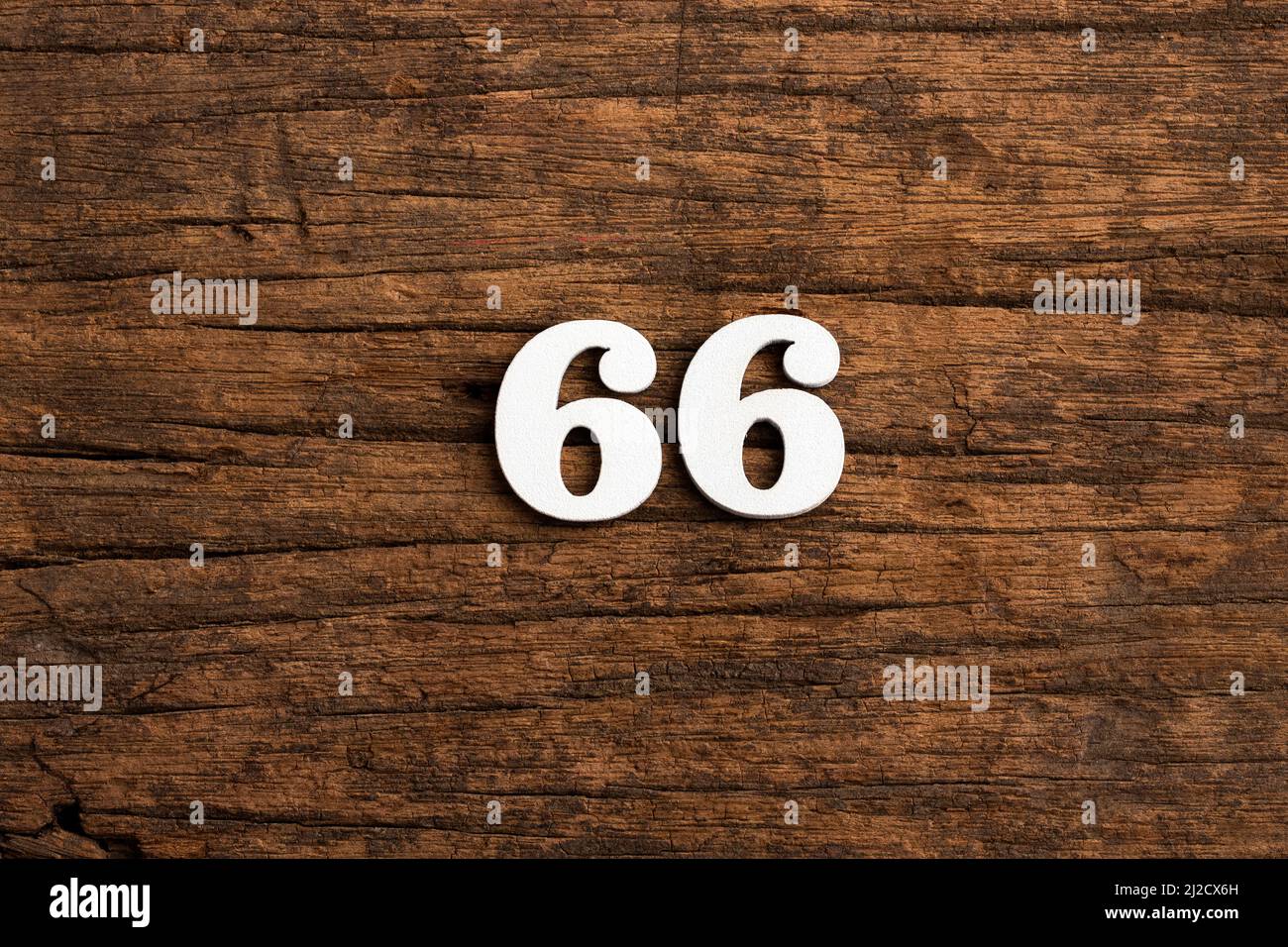 Number 66 in wood, isolated on rustic background Stock Photo - Alamy