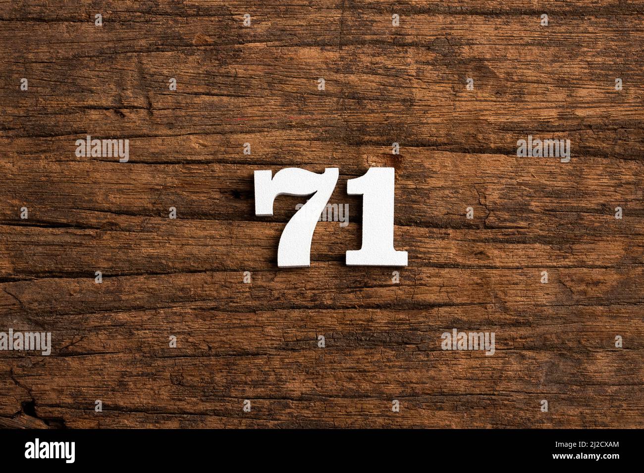 Number 71 - piece on rustic wood background Stock Photo - Alamy