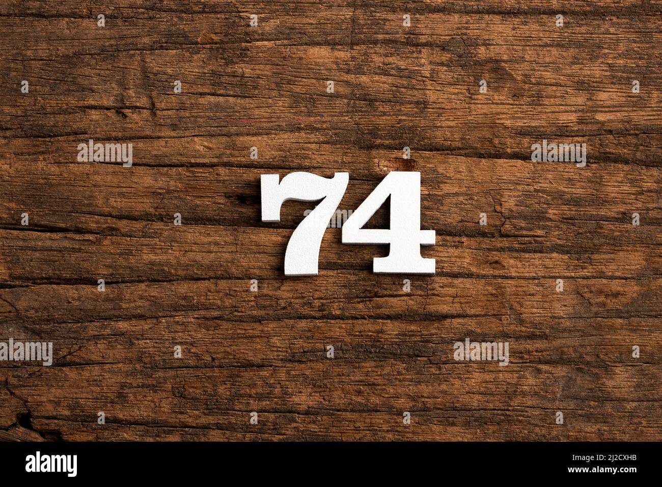 Number 74 in wood, isolated on rustic background Stock Photo - Alamy