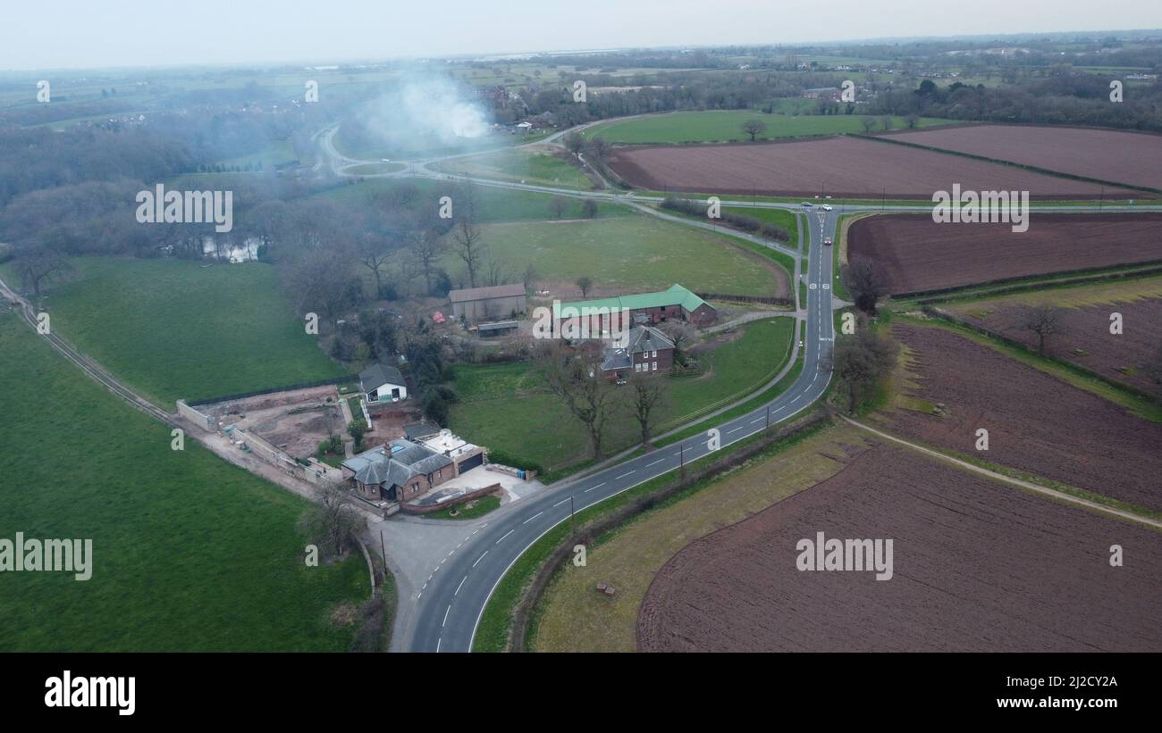 An aerial view of a farm and suburban landscape with smoke rising in ...