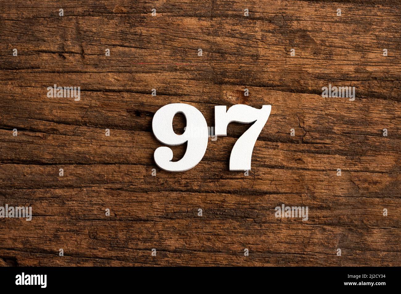 Number 97 - piece on rustic wood background Stock Photo - Alamy