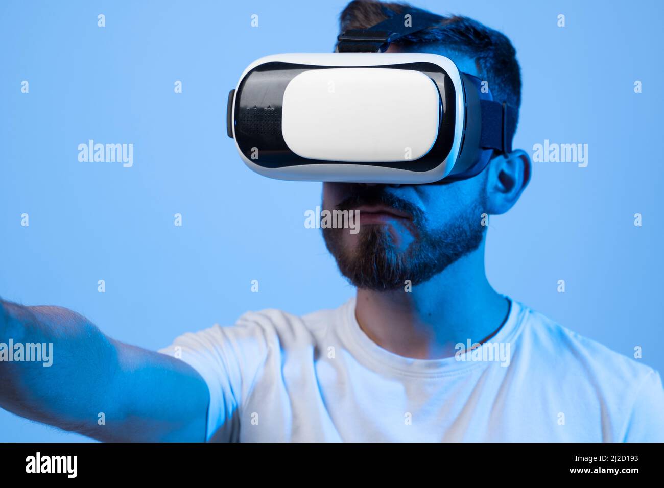 Young man using VR headset helmet to play simulation game. Watching ...