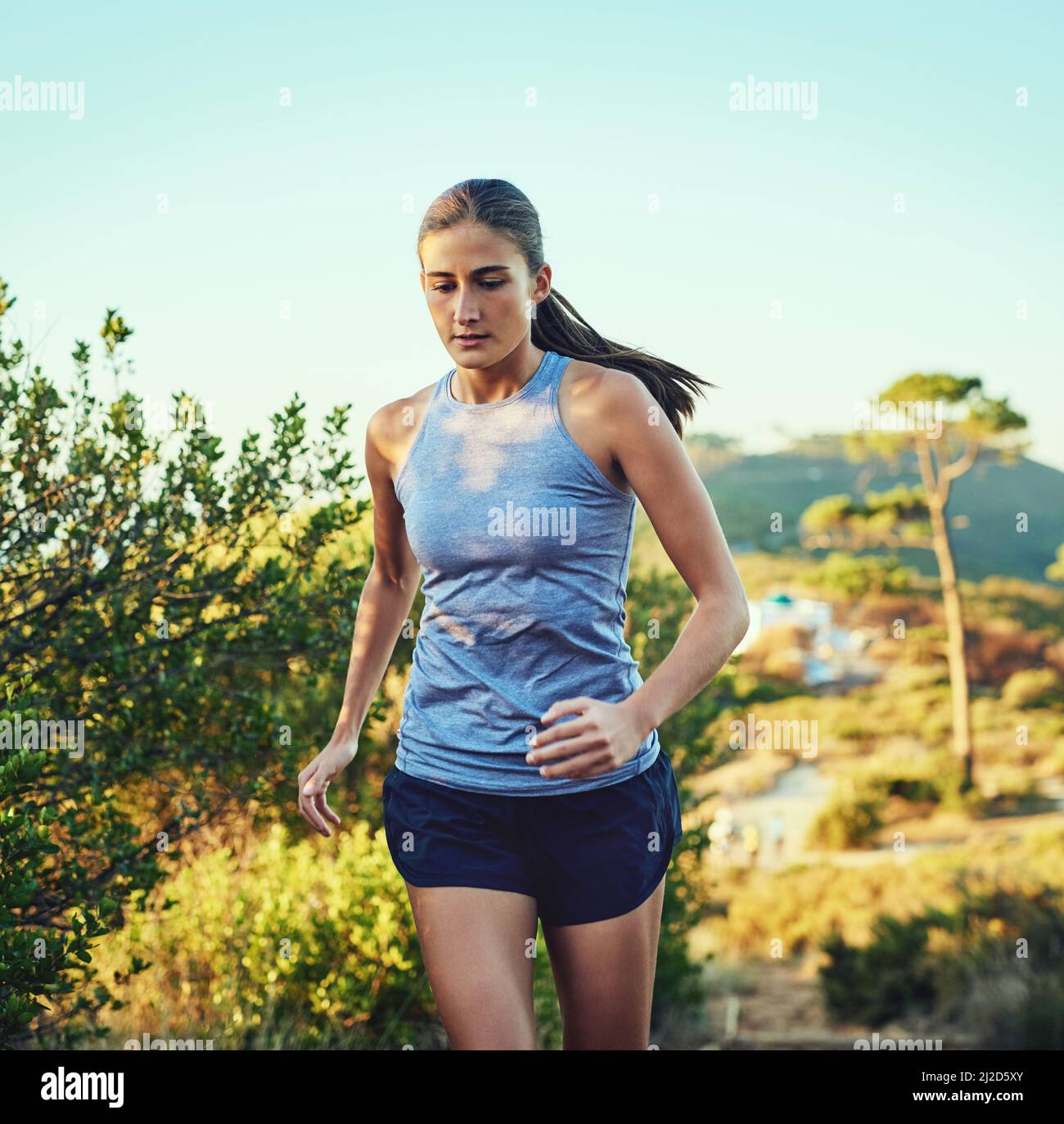 Keeping a steady but strong pace. Shot of a young woman out for a run ...