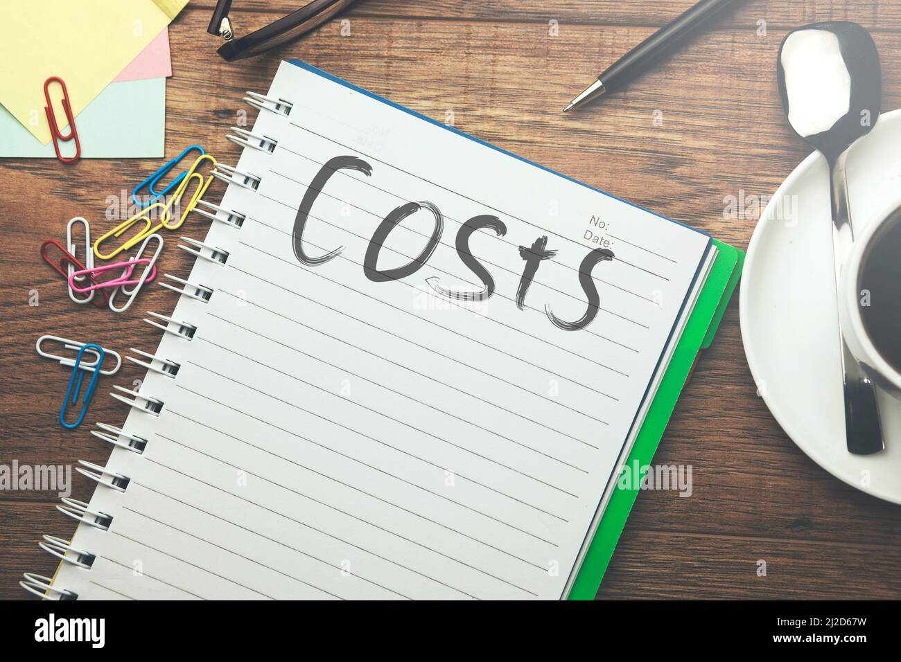 costs text on notebook on working table Stock Photo - Alamy