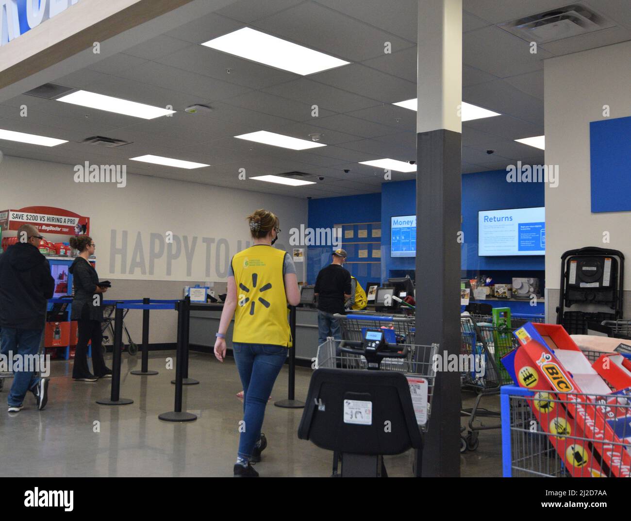 A worker walking towards a customer service area within a Walmart store ...