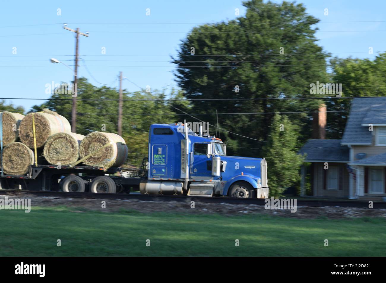 A semi-truck and trailer hauling hay drives through the town of Windom ...