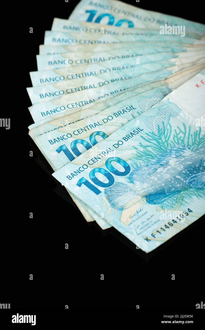 Brazilian money. One hundred reais banknotes with black background ...
