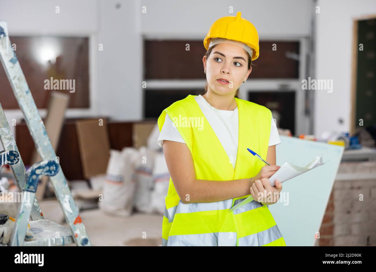 Young woman builder checking documentation in construction site Stock ...