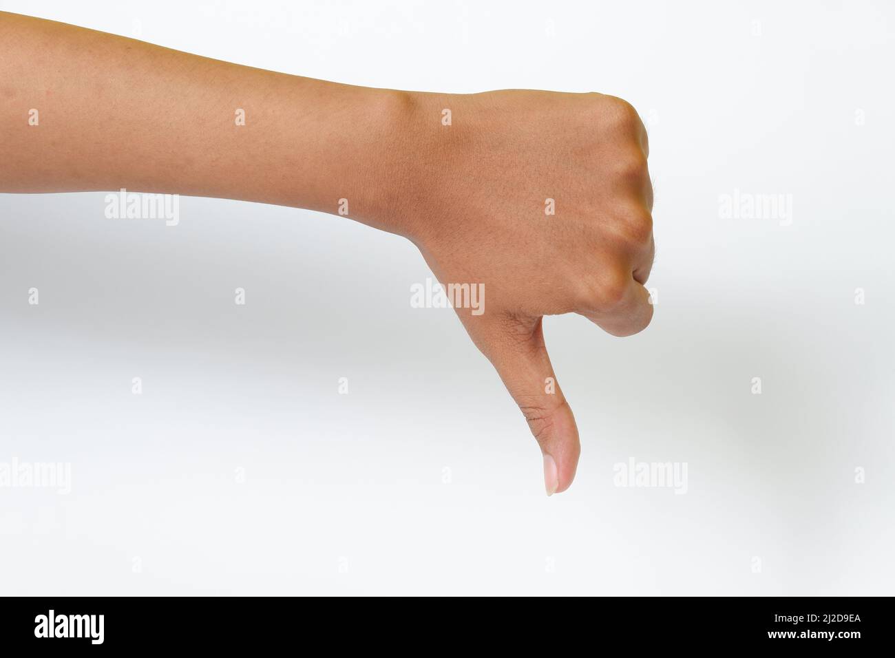 An adult female hand showing thumb down sign isolated on a white ...