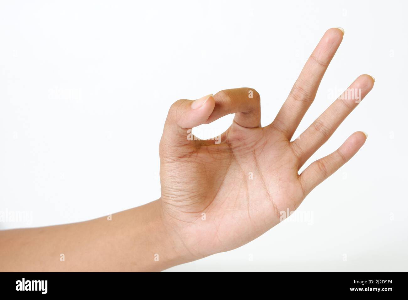 An adult female hand showing the OK sign isolated on a white background ...
