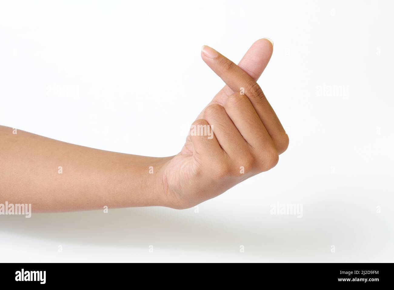 An adult Caucasian female hand showing the finger heart gesture ...